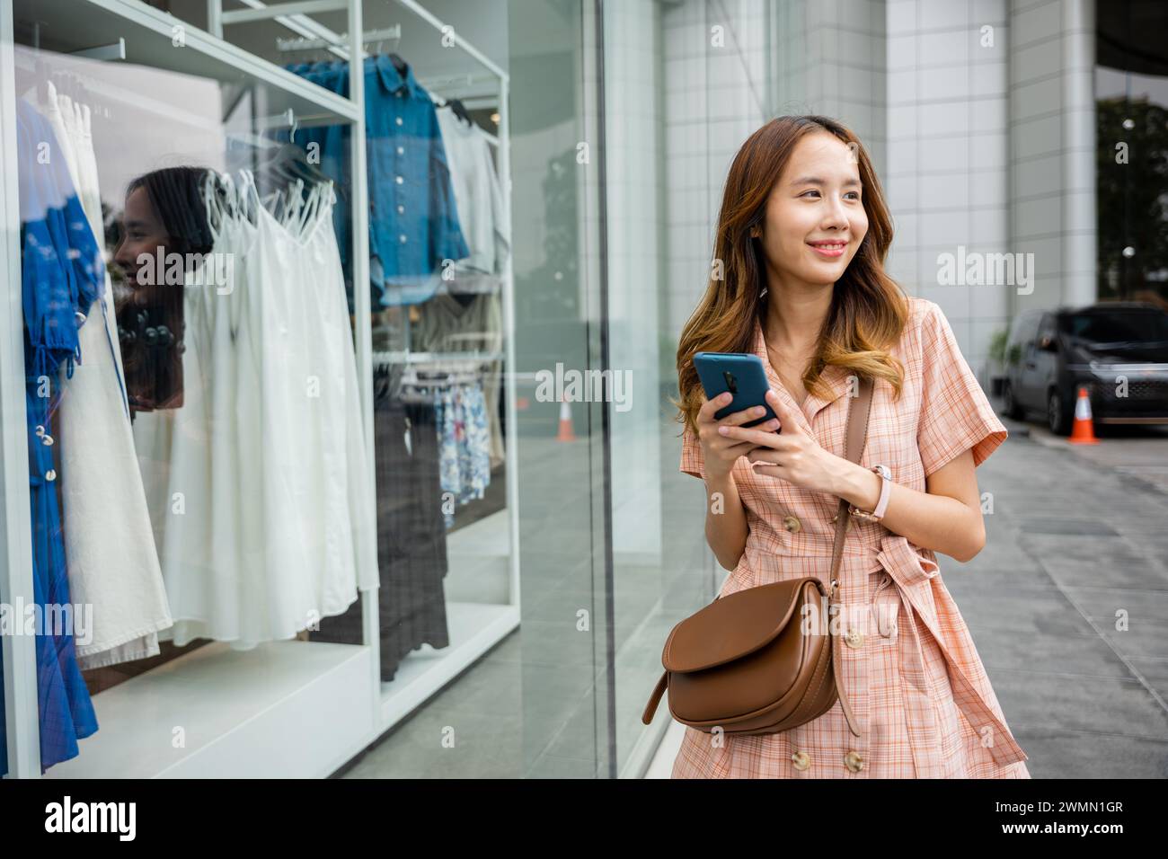 woman scrolling through her phone with a smile on her face outdoor Stock Photo - Alamy