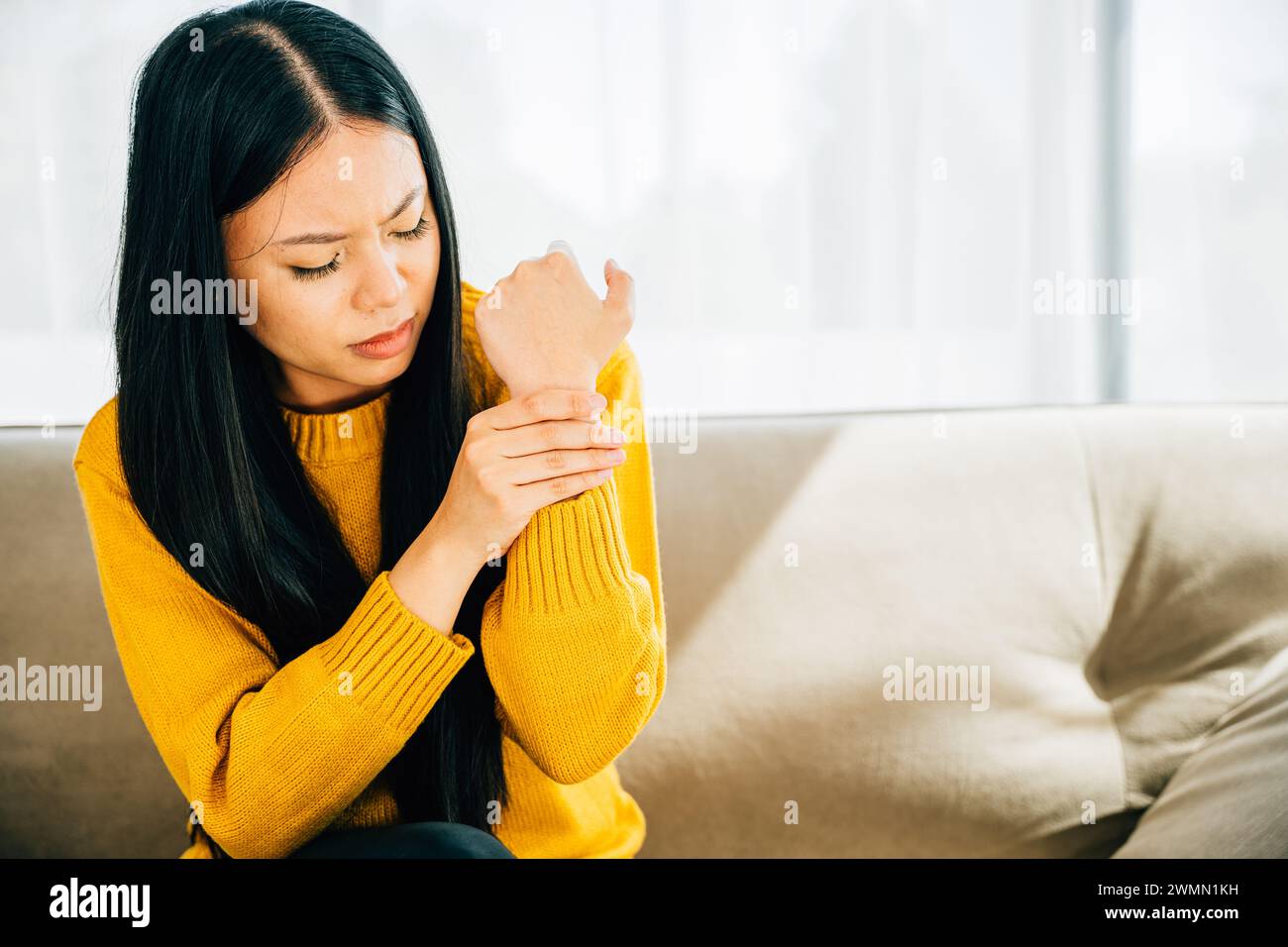 Woman holds her achy hand suggesting Carpal Tunnel Syndrome or ...