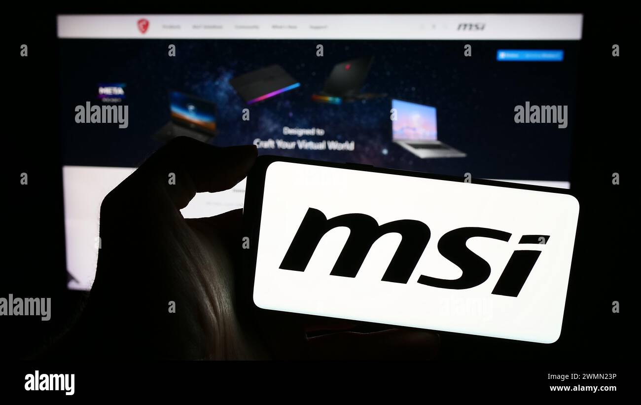 Person holding mobile phone with logo of Taiwanese company Micro-Star ...