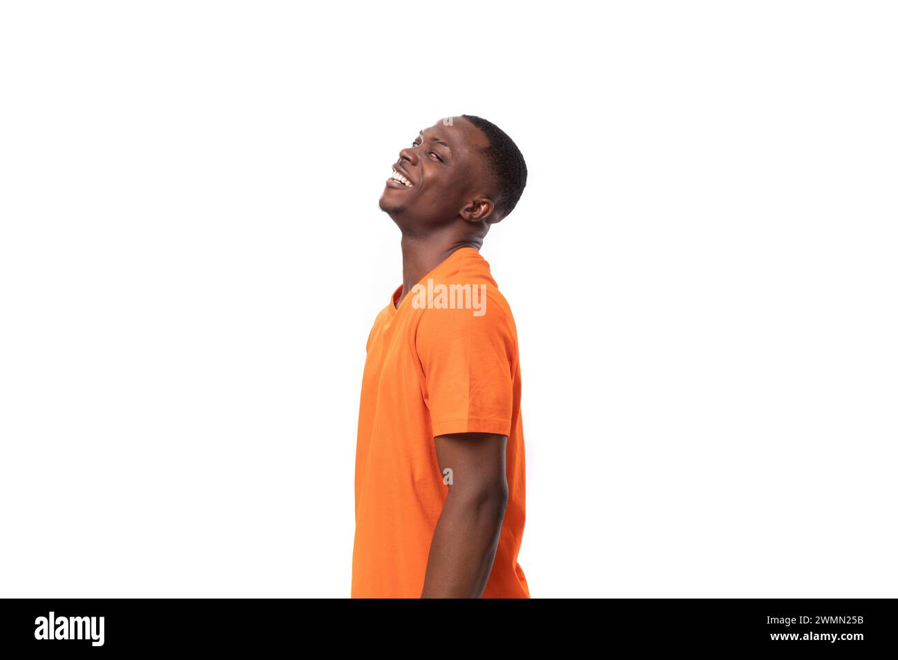 young slender American man dressed in an orange cotton t-shirt with a ...