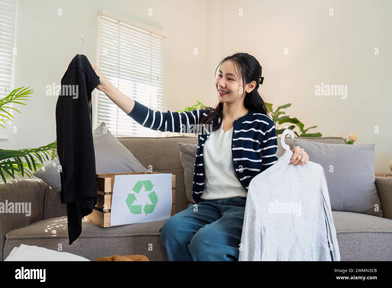 Asian women sort clothes from old clothing box to recycle. Recycling ...