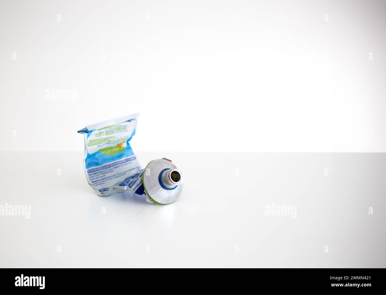 Used up squeezed out metal paste tube ready for recycling close up ...