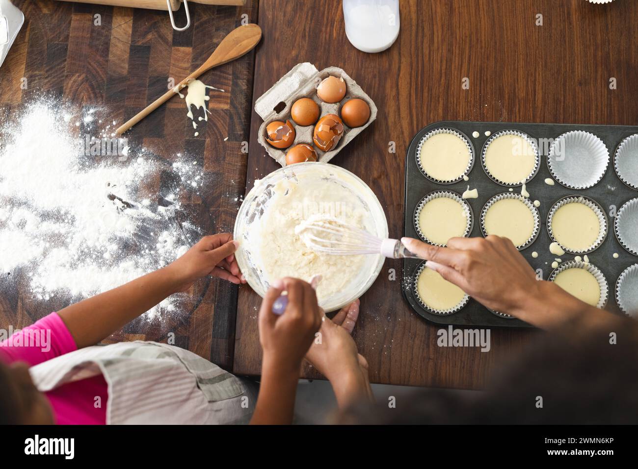 Biracial mother and daughter baking together at home for daughter. They ...