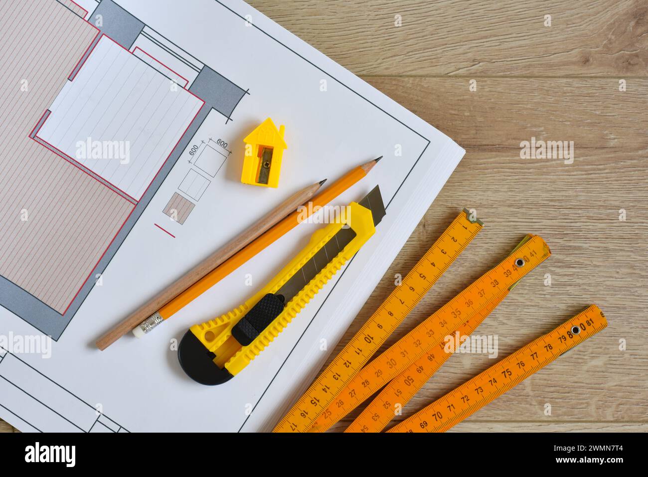 Architectural drawings and pencils, ruler, clerical knife on wooden ...