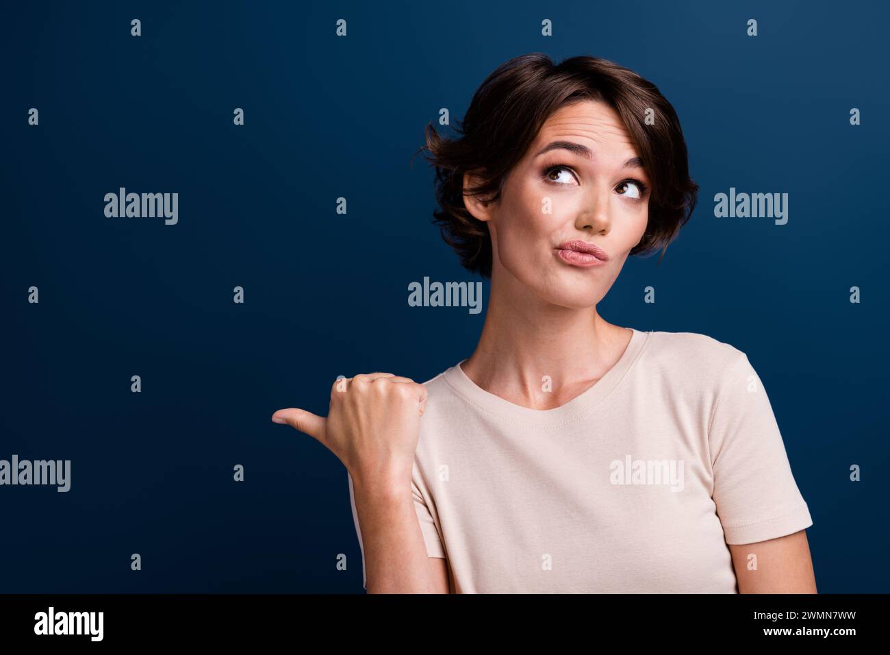 Portrait of uncertain lady looking directing finger empty space ...