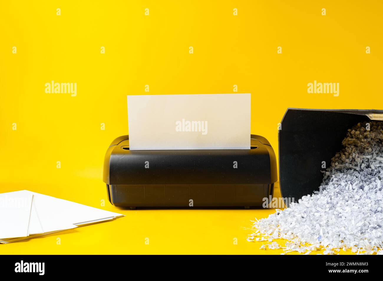 Office paper shredder on yellow studio background Stock Photo - Alamy