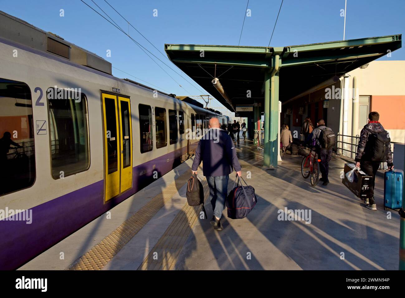 Passengers getting on an electric train of the OSE Greek railway at the ...