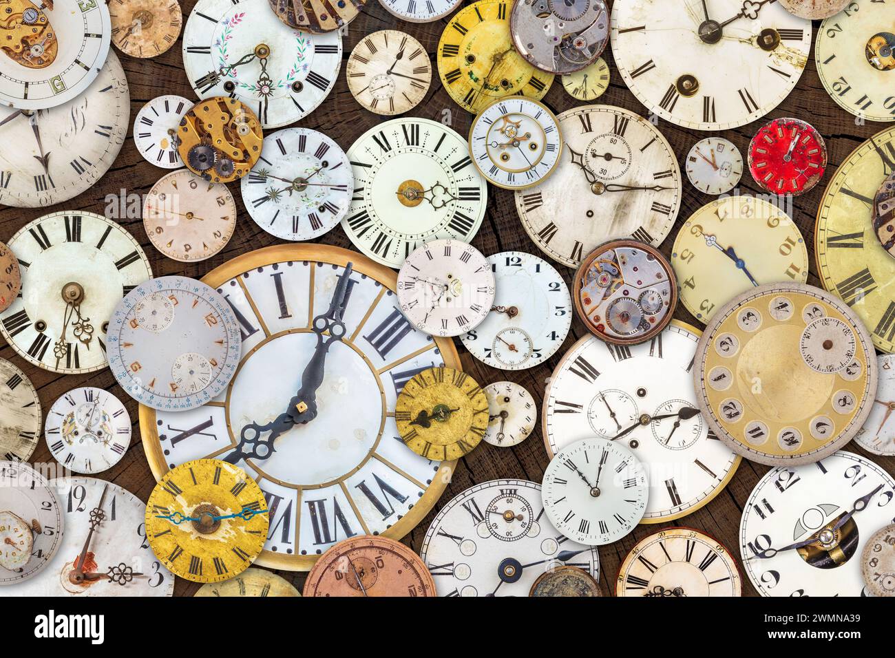 Collection of vintage weathered clocks and watches on a wooden ...