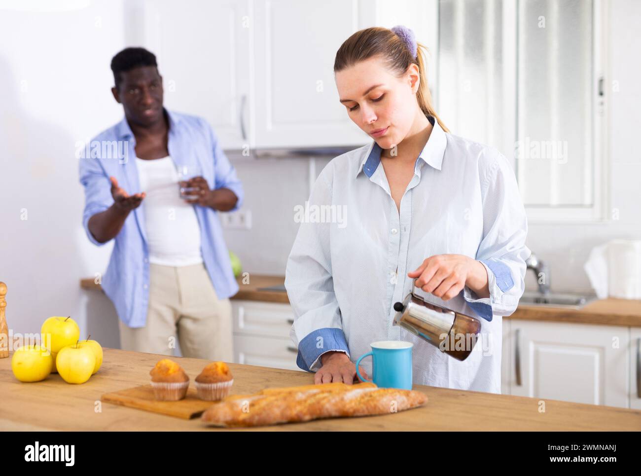 Upset young woman pouring coffee into cup on background of dissatisfied ...