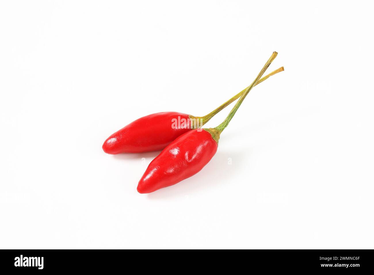 Two small red chili peppers on white background Stock Photo - Alamy