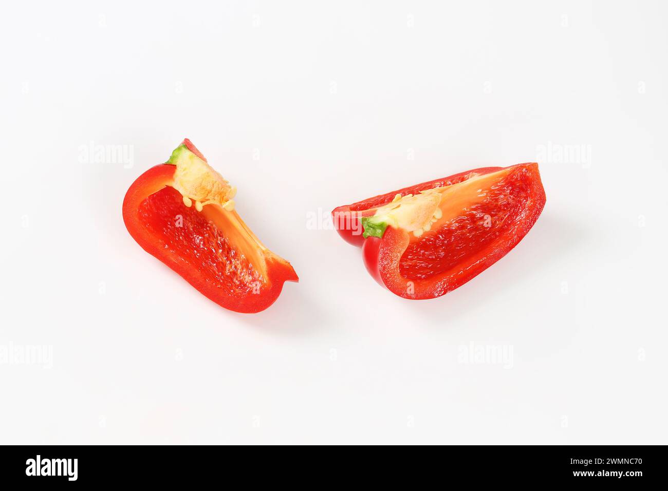 Two red bell pepper quarters on white background Stock Photo - Alamy