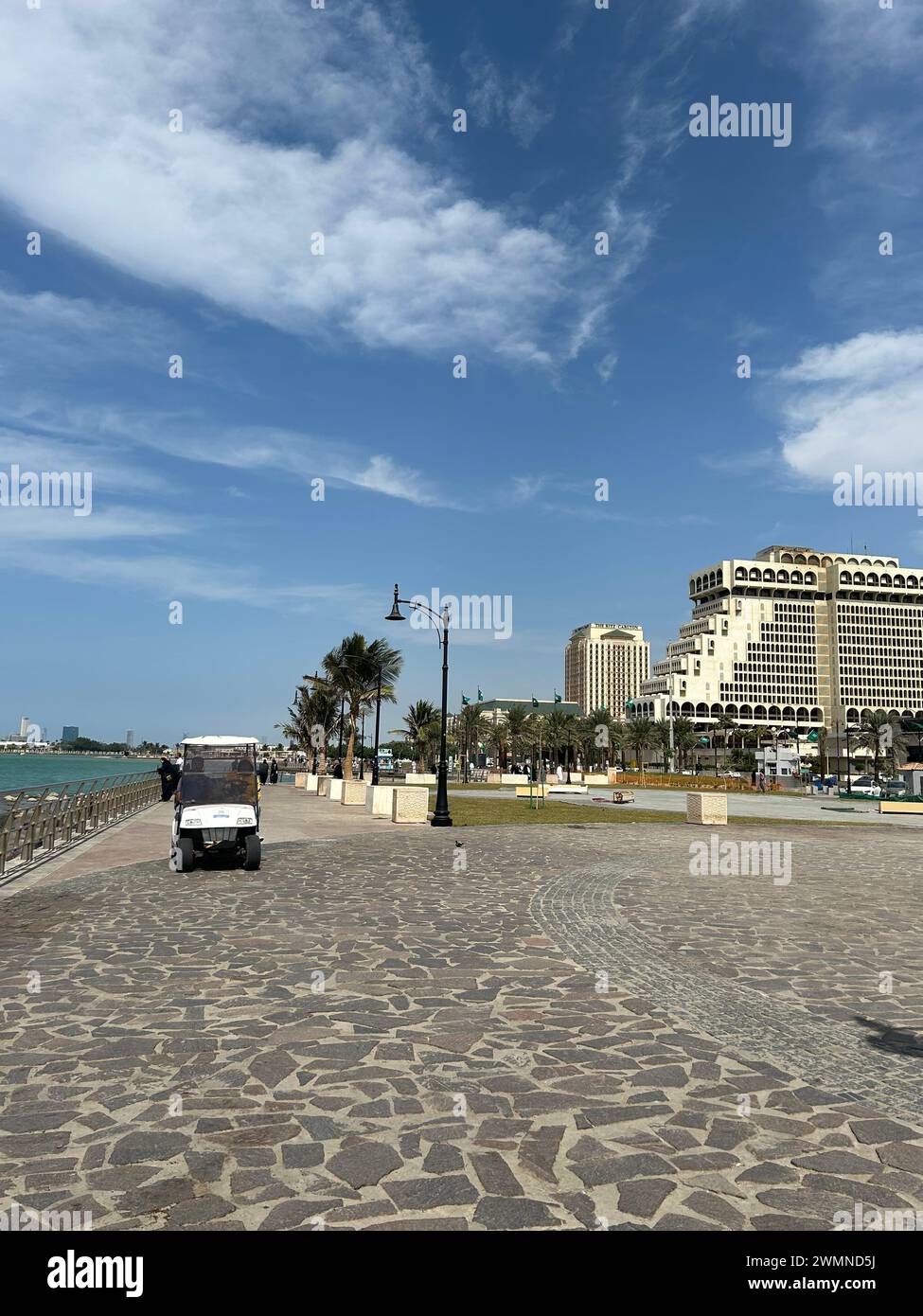 A beachfront pathway with distant buildings in the background Stock ...
