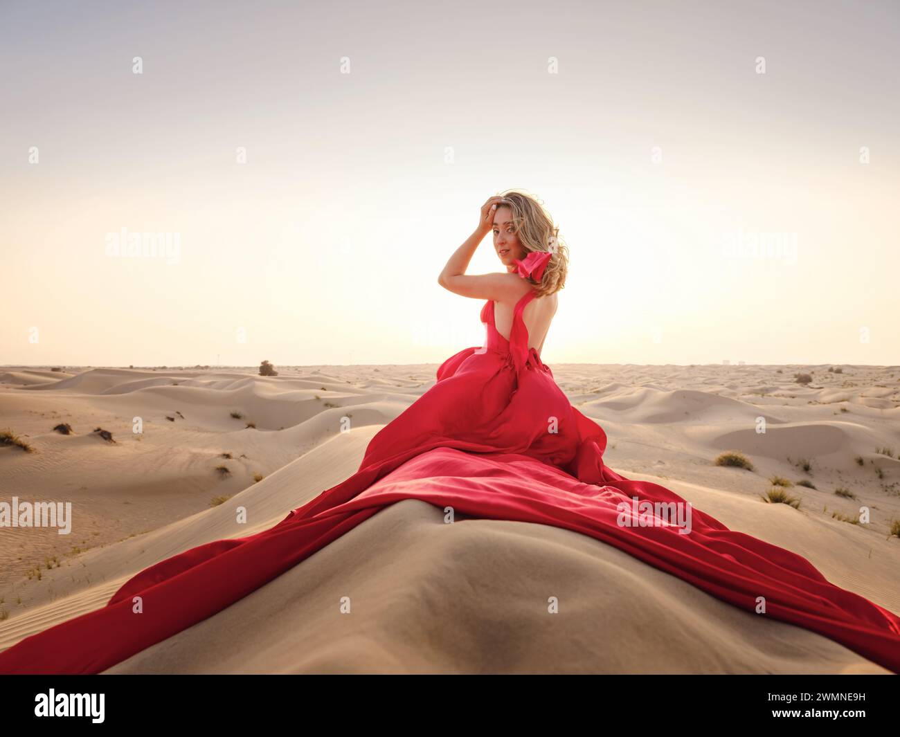Desert adventure. Young arabian Woman in red silk dress in sands dunes ...
