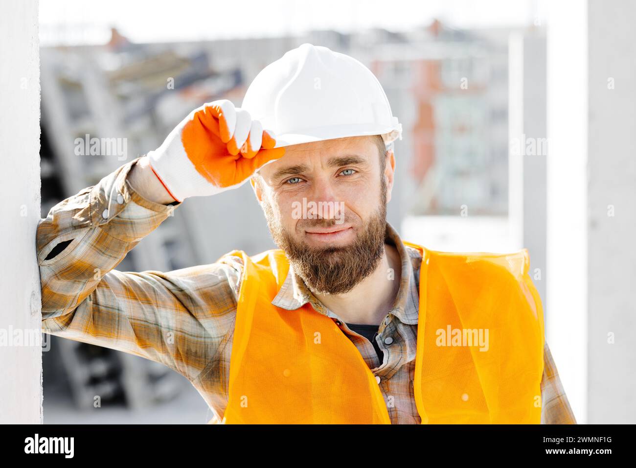 Builder repairman, foreman in safety helmet and vest works at his ...