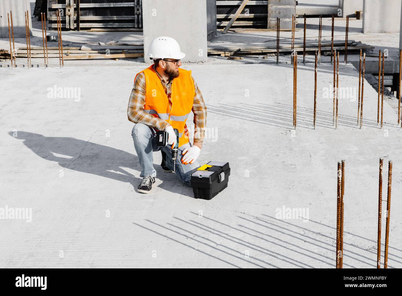 Repairman worker in uniform and helmet working with cordless ...