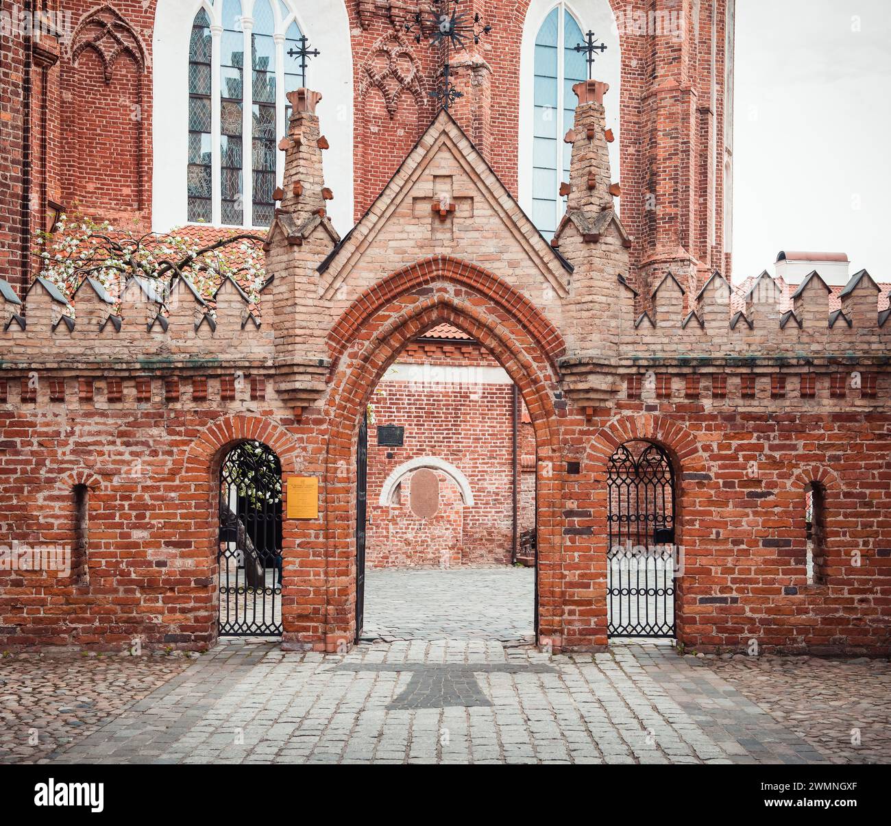 symmetric photo of brick gate near gothic Church of St. Anne. Spring in ...