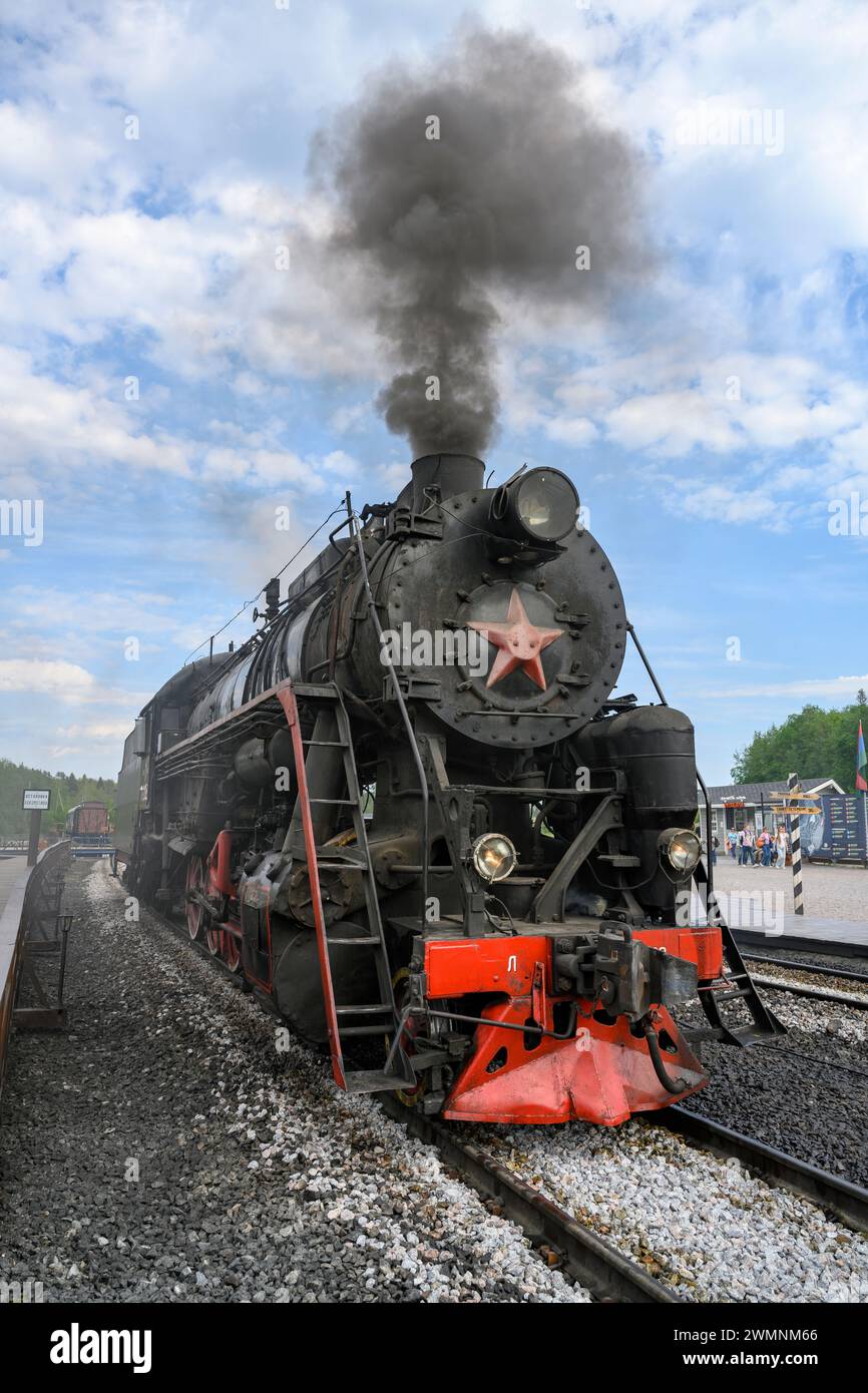 A retro steam locomotive of the mid-20th century with a smoking pipe ...