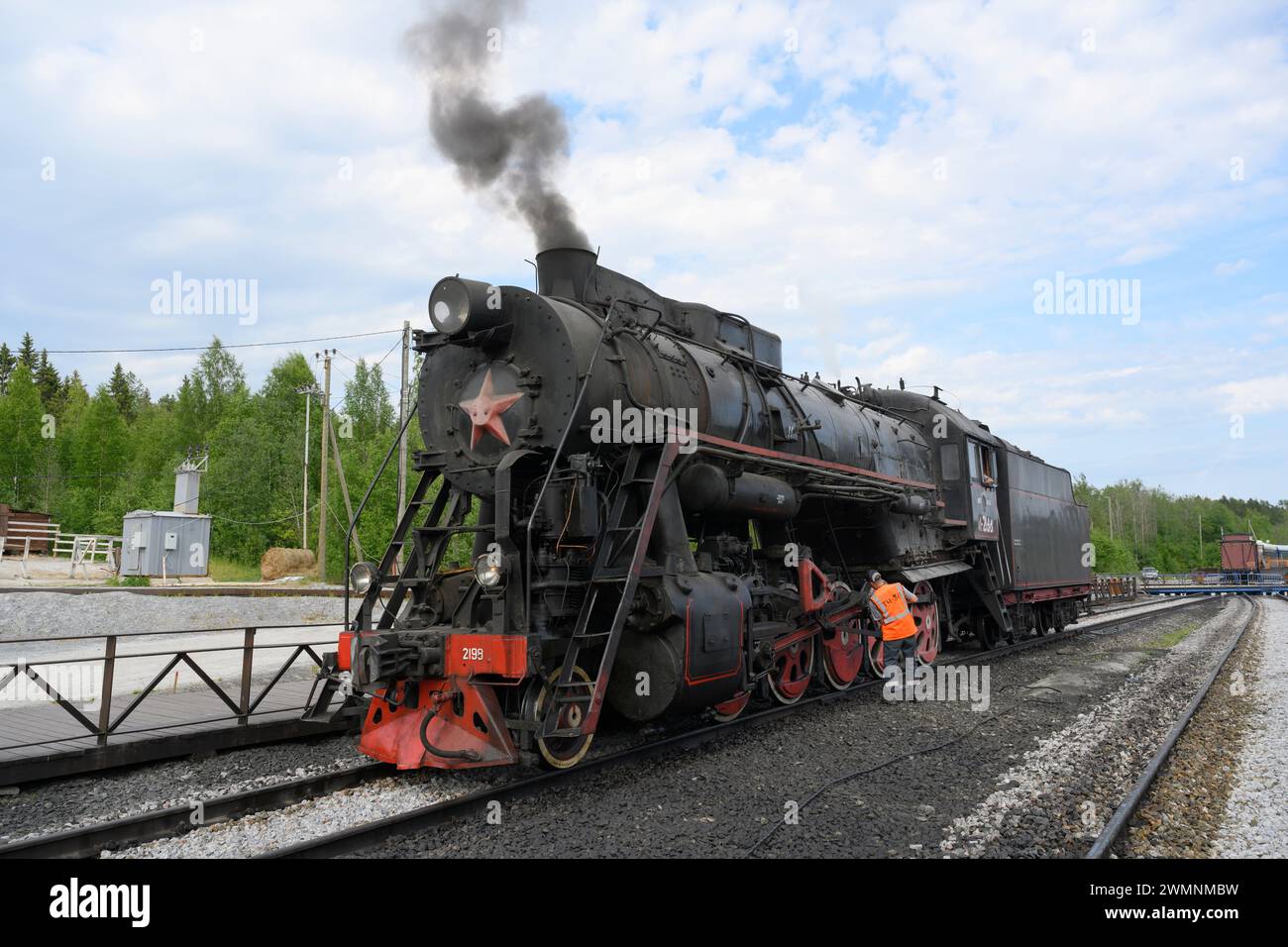 A retro steam locomotive of the mid-20th century with a smoking pipe ...