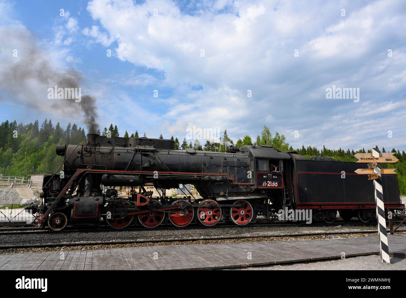 A retro steam locomotive of the mid-20th century with a smoking pipe ...