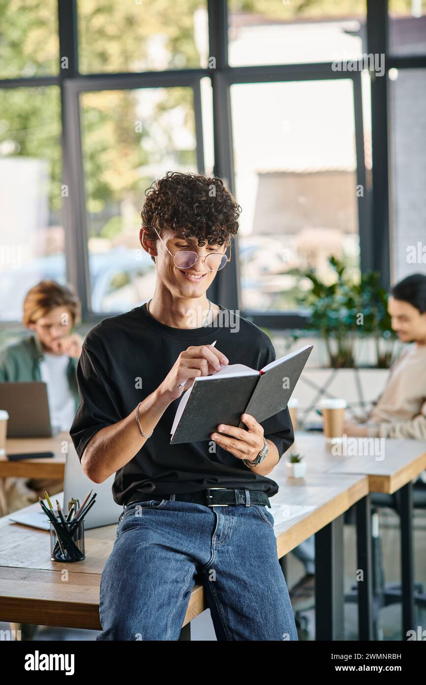 Curly-haired man with glasses smiling and taking notes in a dynamic ...