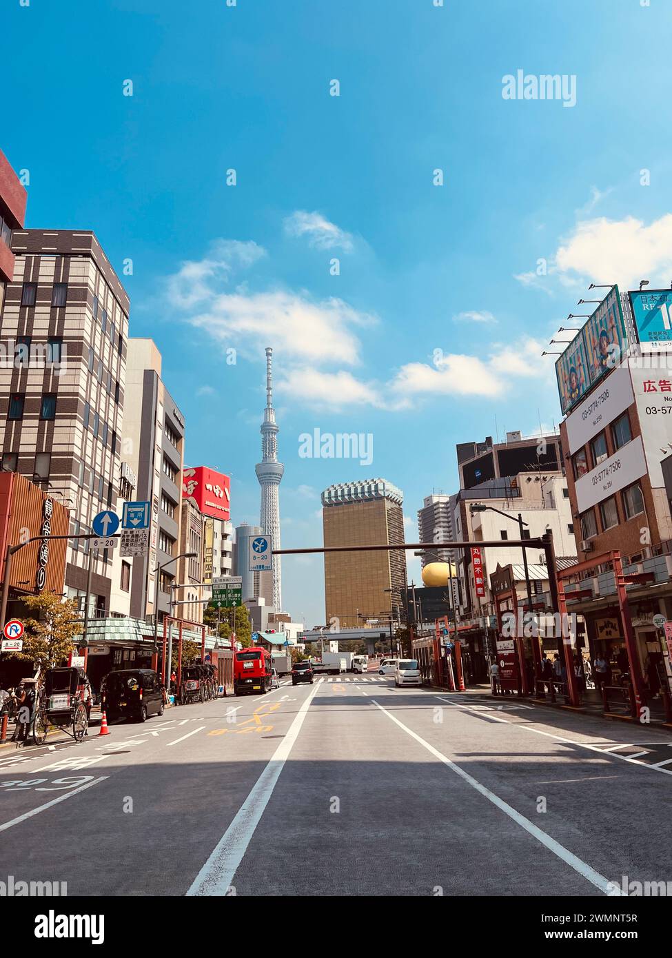 A city street flanked by high-rise buildings and a towering clock tower ...