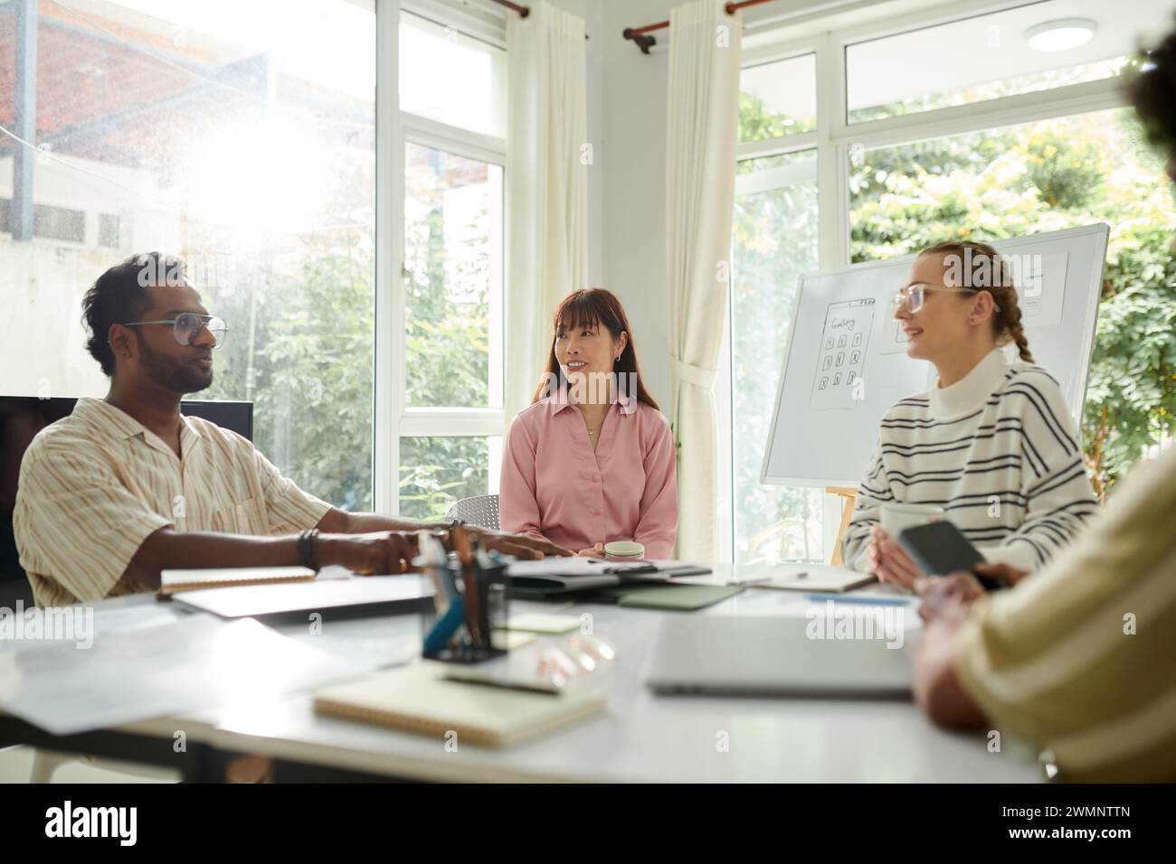 Team listening to colleague sharing his option on project development ...