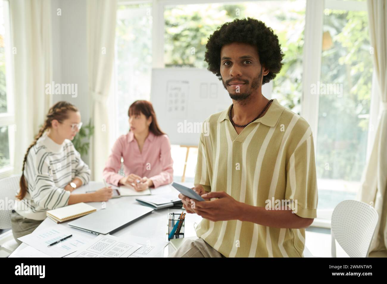 Portrait of Black man testing new mobile application his colleagues ...