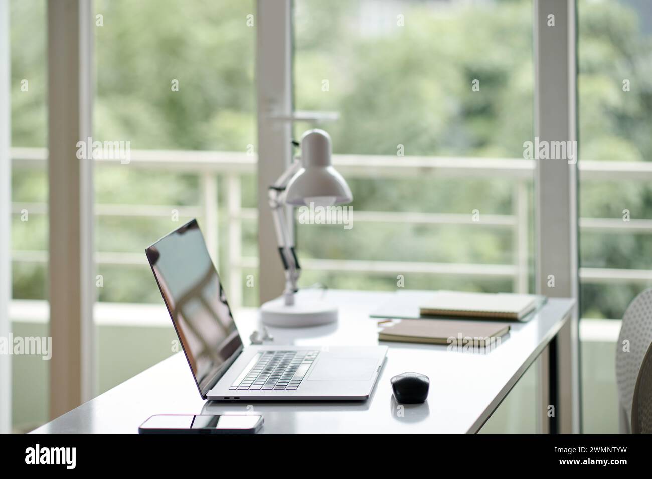 Opened laptop, planner and lamp on office desk next to big window Stock ...