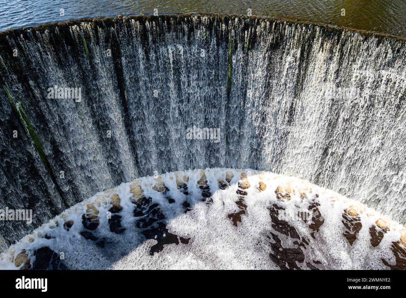 Water flows from a small semi-circular dam in a small village by the ...