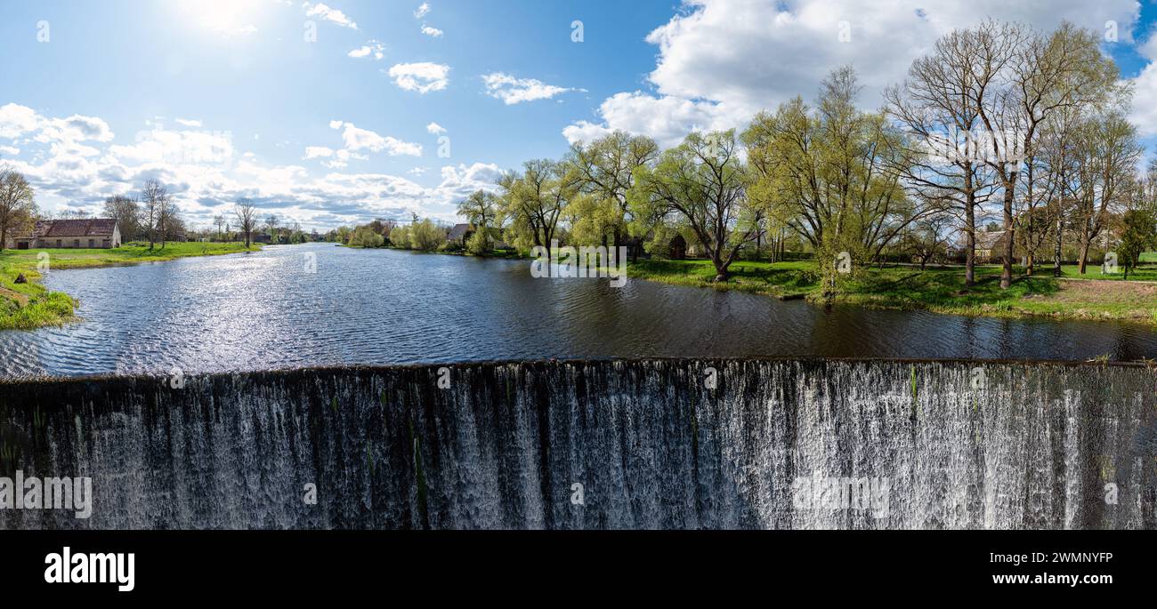 Water flows from a small semi-circular dam in a small village by the ...