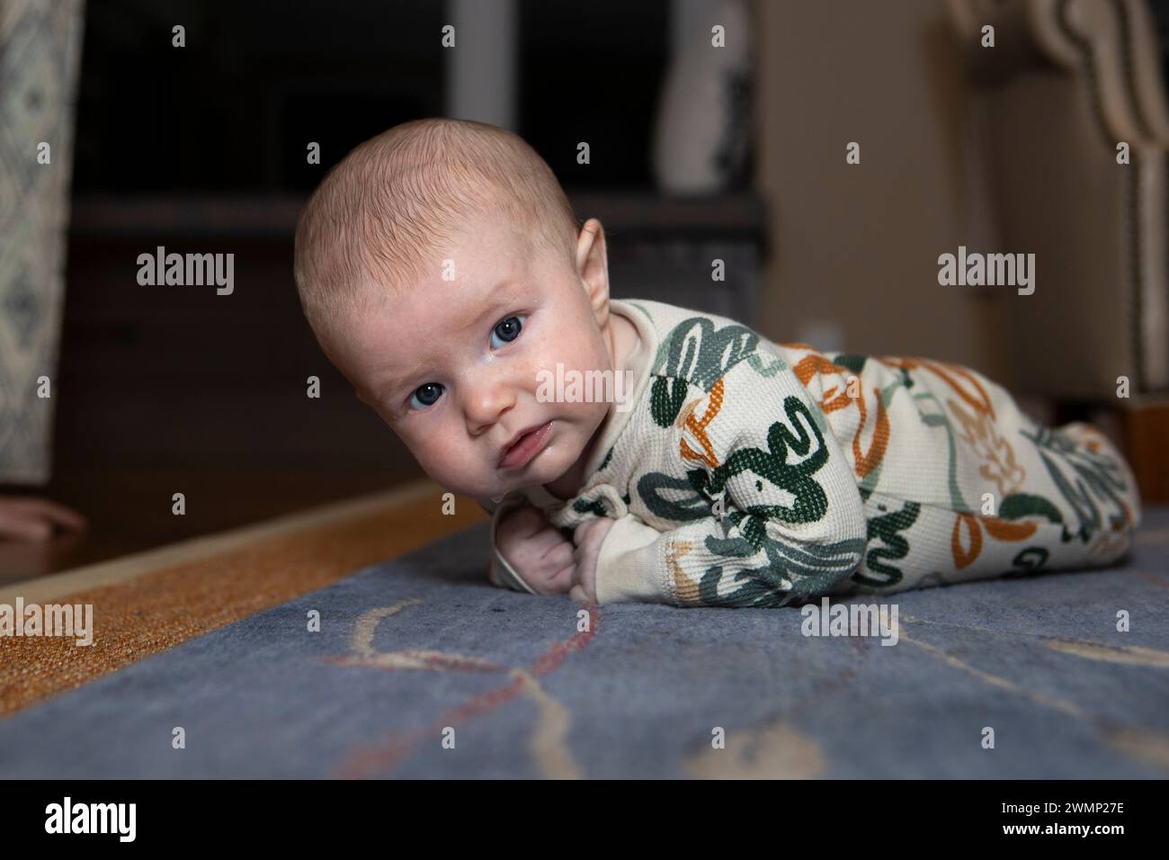 Two and a half month old baby boy enjoying tummy time on the floor ...