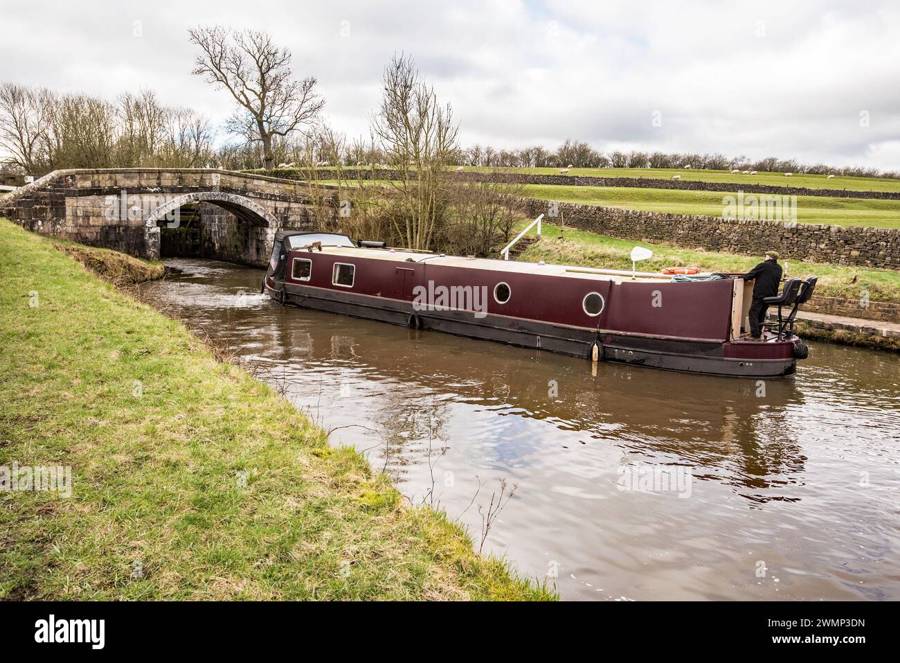 Narrowboat operator waiting whilst his fiend attends to the lock gates ...
