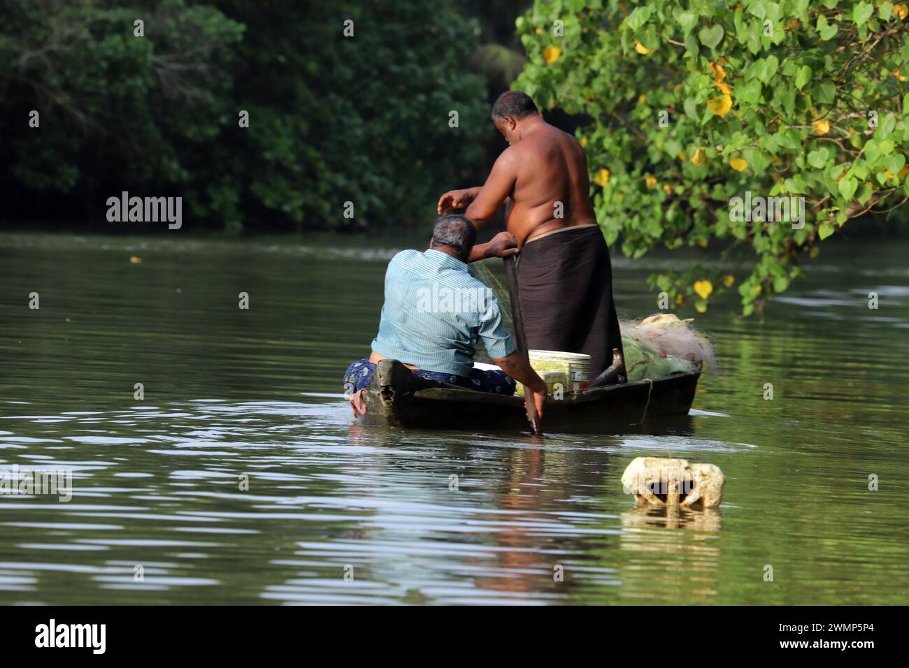 Fishermen in a canoe laying out nets. Munroe Island, Kerala, India ...