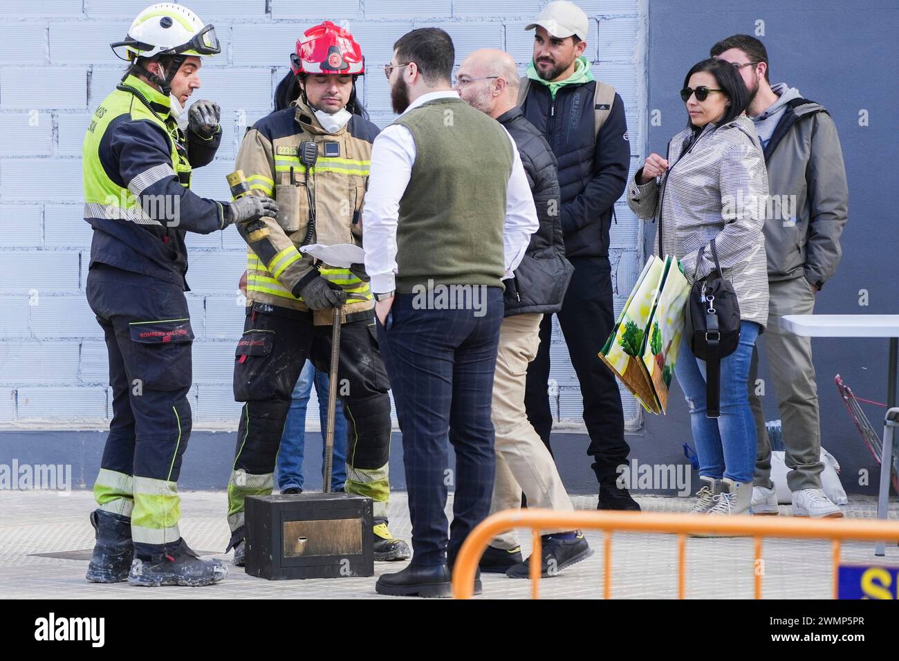 Firefighters with some of those affected by the building fire, in the ...