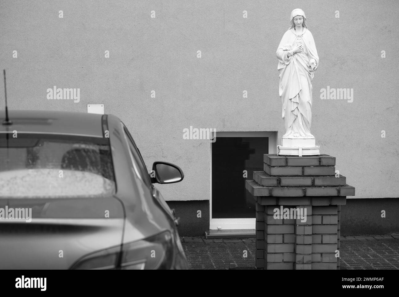 Jesus Christ statue next to an expensive car. Catholic church in Poland ...