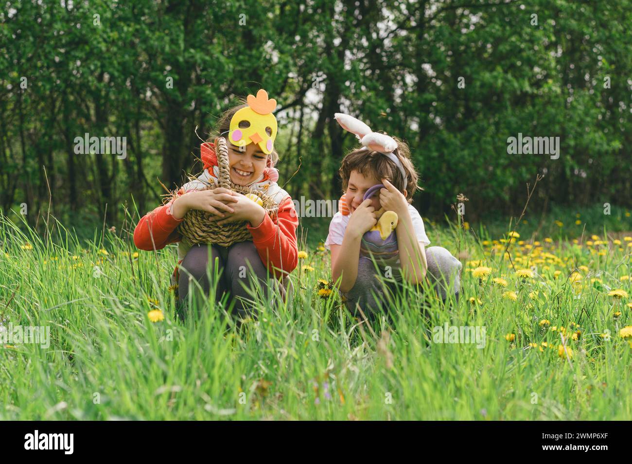 Two children hunt for Easter eggs in a spring garden. Easter tradition ...