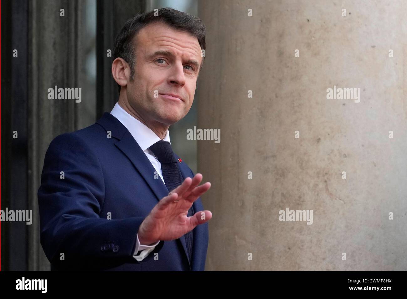 French President Emmanuel Macron, waves reporters as he waits for Qatar ...