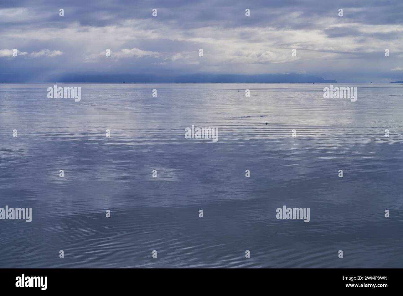 Minimalist view of an approaching rainstorm over a calm serene blue ...