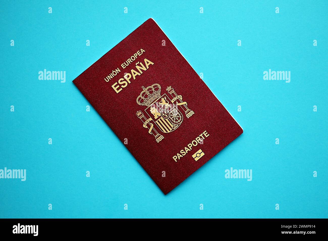 Red Spanish passport of European Union on blue background close up ...