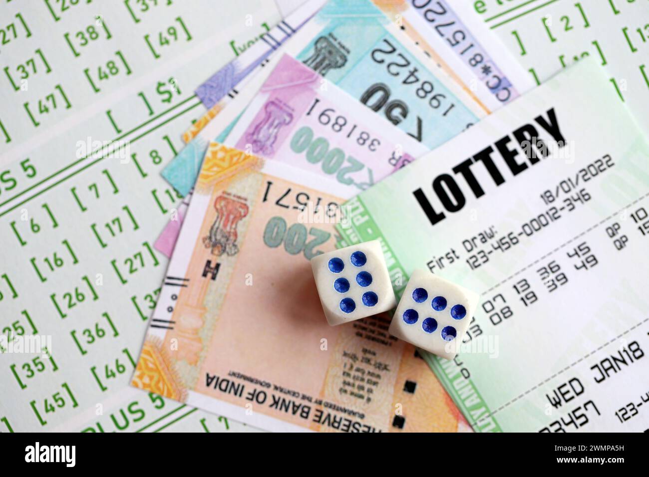 Green lottery tickets and indian rupees money bills on blank with ...