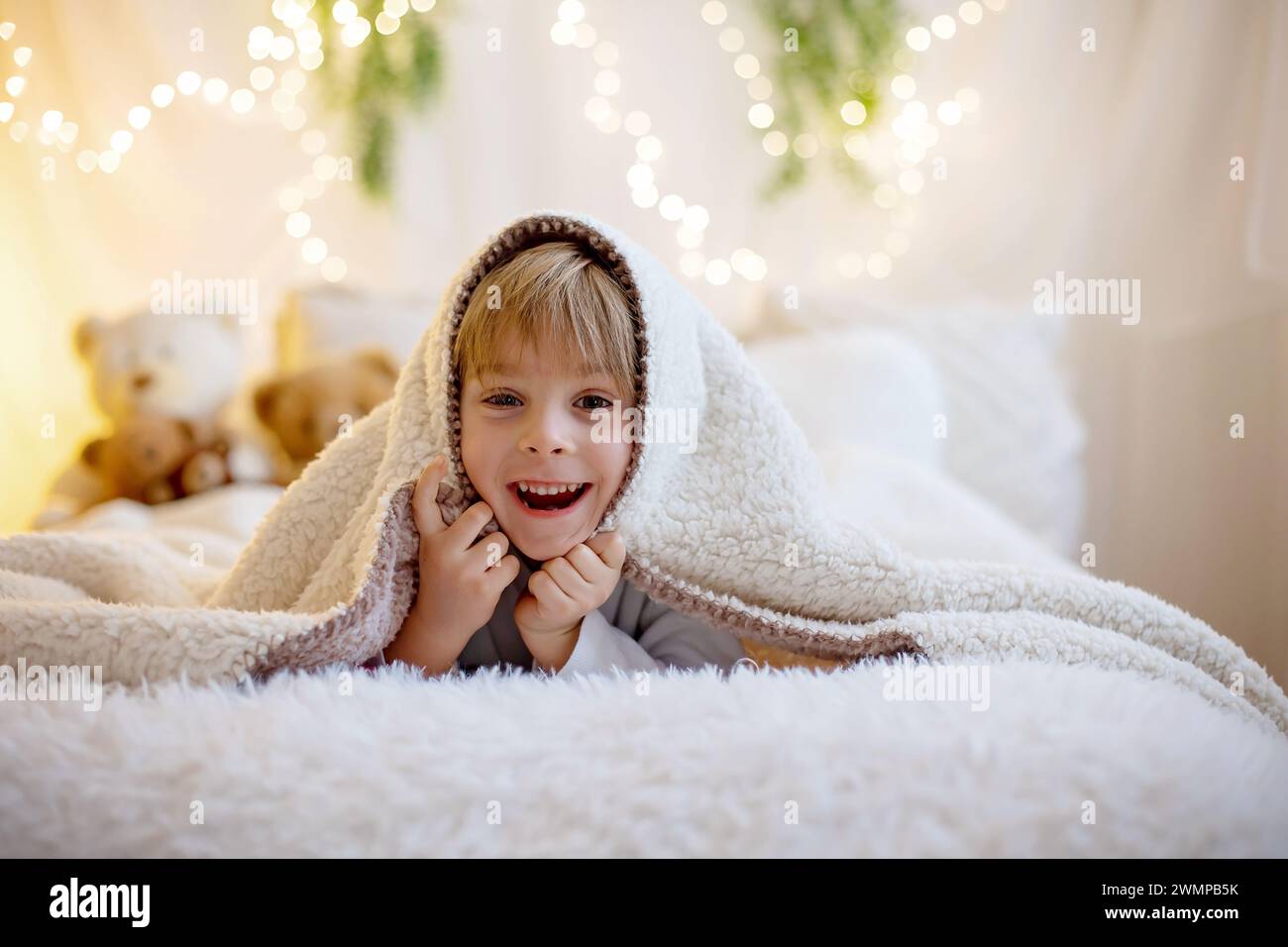 Little cute preschool boy, holding cute teddy bear, hiding under ...