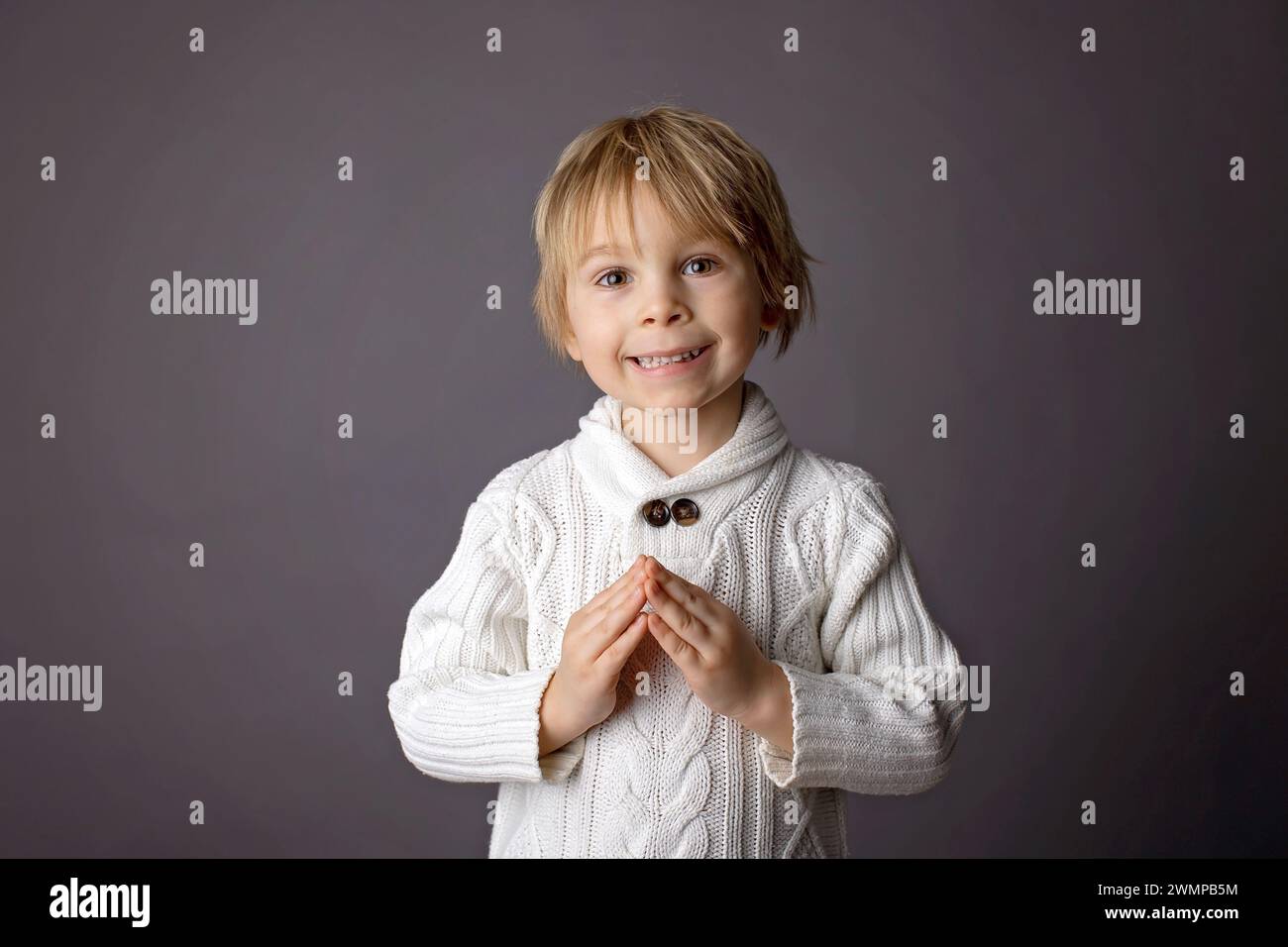 Cute little toddler boy, showing home gesture in sign language on gray ...