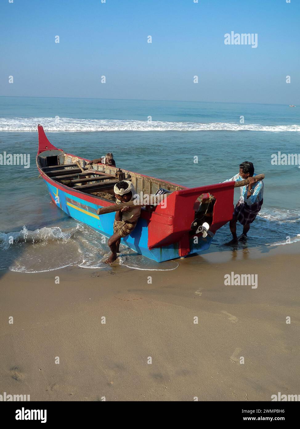 India, Kerala, Varkala: a group of indian fishermen pushes a ...
