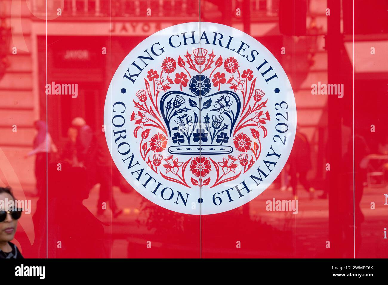 People walk past the coronation emblem as London prepares for the ...