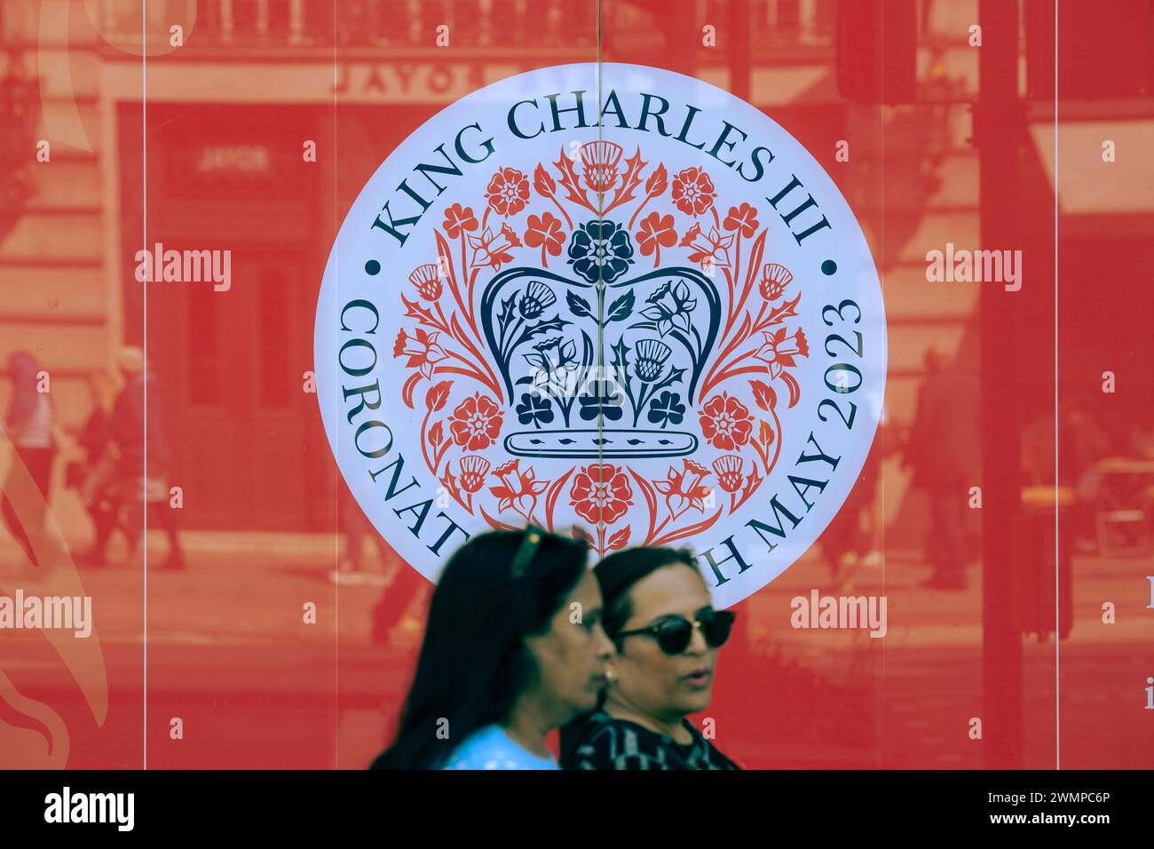 People walk past the coronation emblem as London prepares for the ...