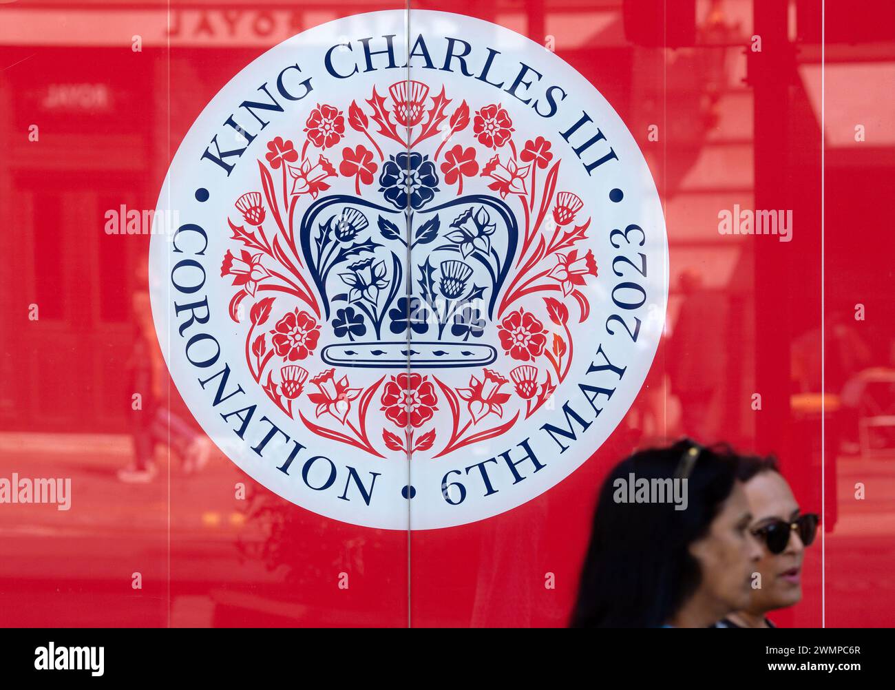 People walk past the coronation emblem as London prepares for the ...