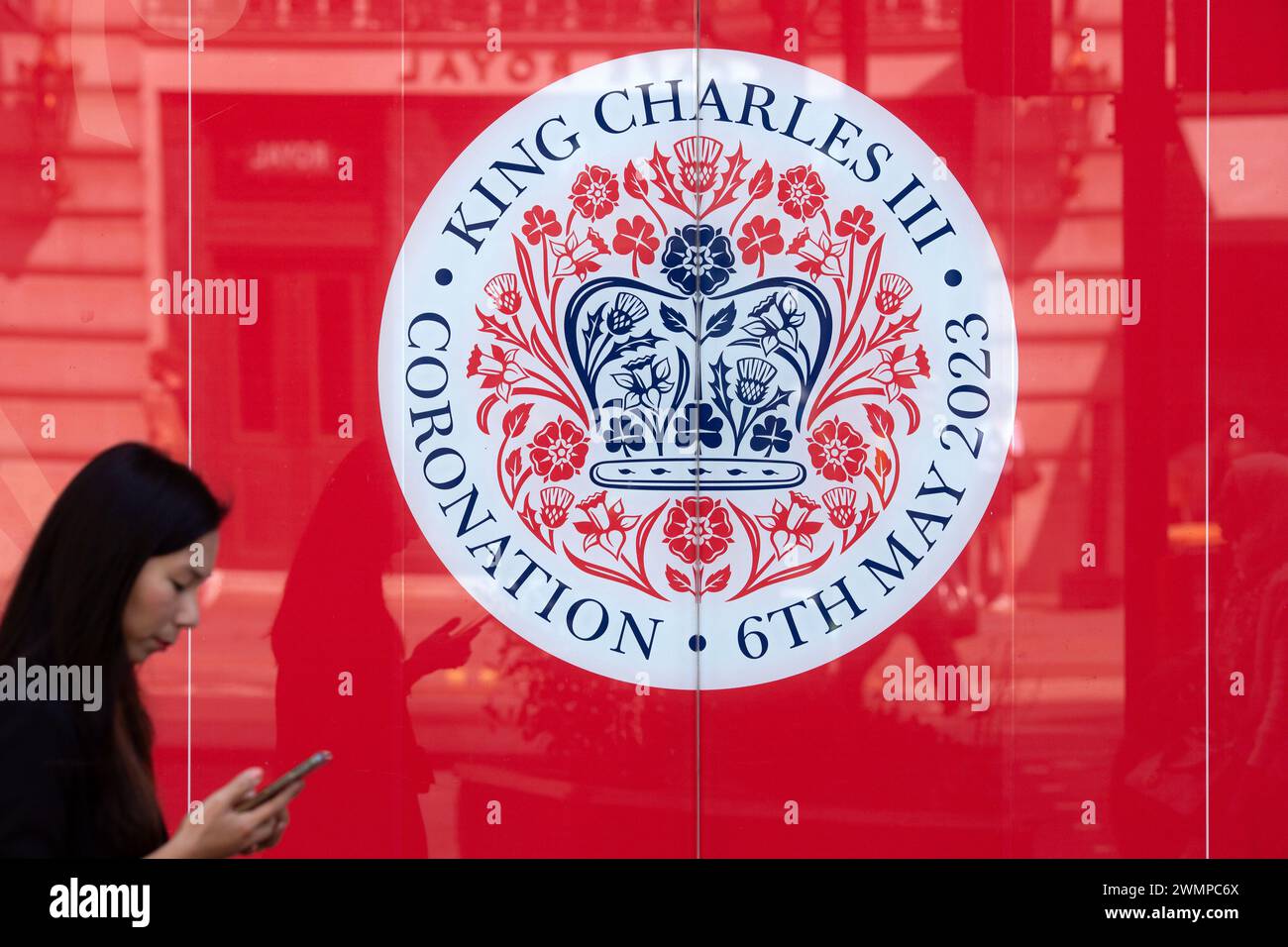 People walk past the coronation emblem as London prepares for the ...