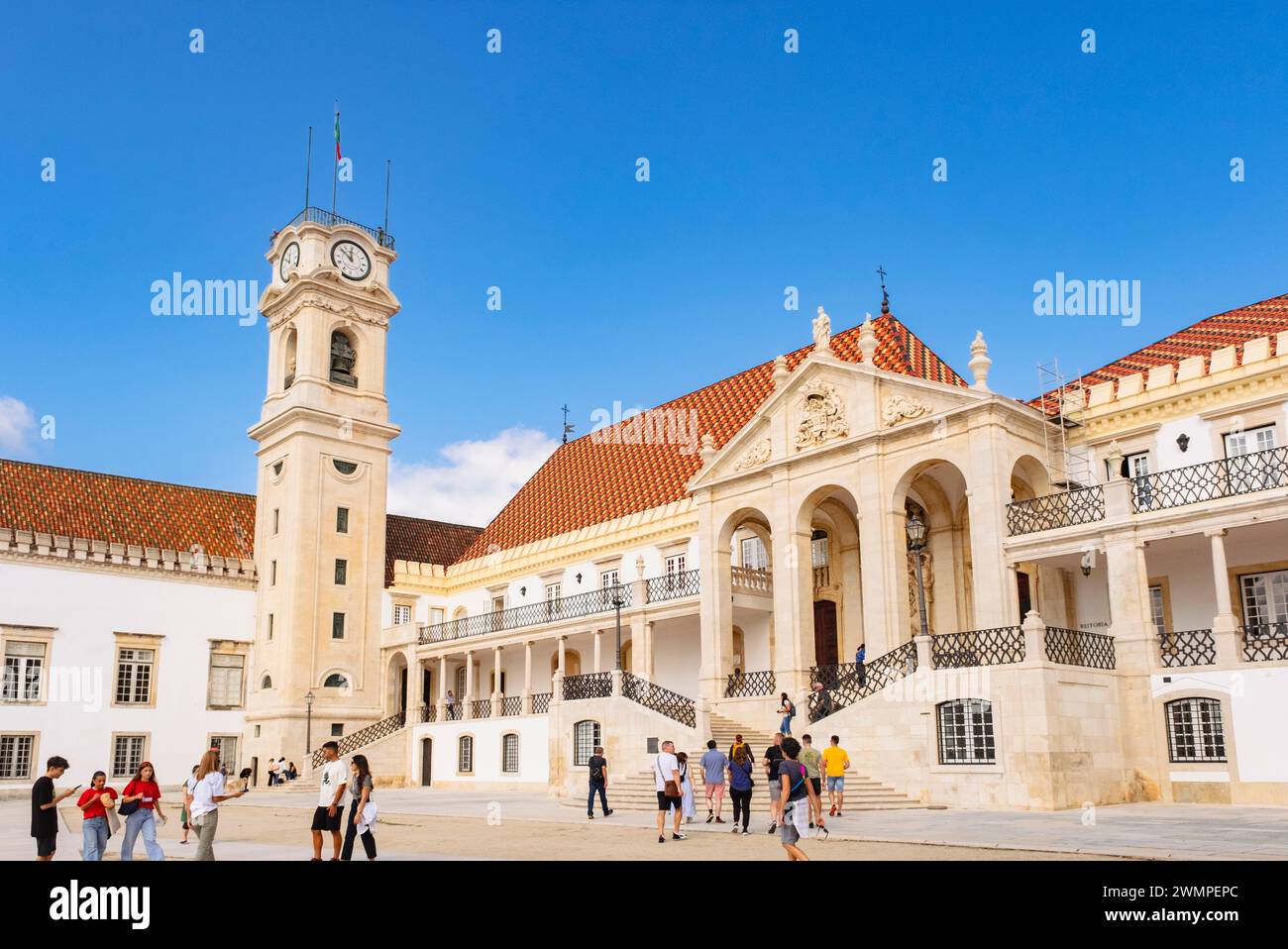 Tourists visiting University of Coimbra courtyard and clock tower ...