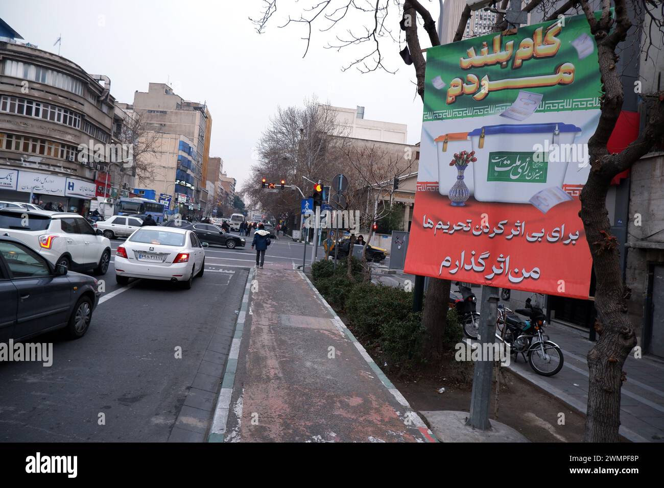 Tehran, Iran. 27th Feb, 2024. Vehicles drive next to a general election ...