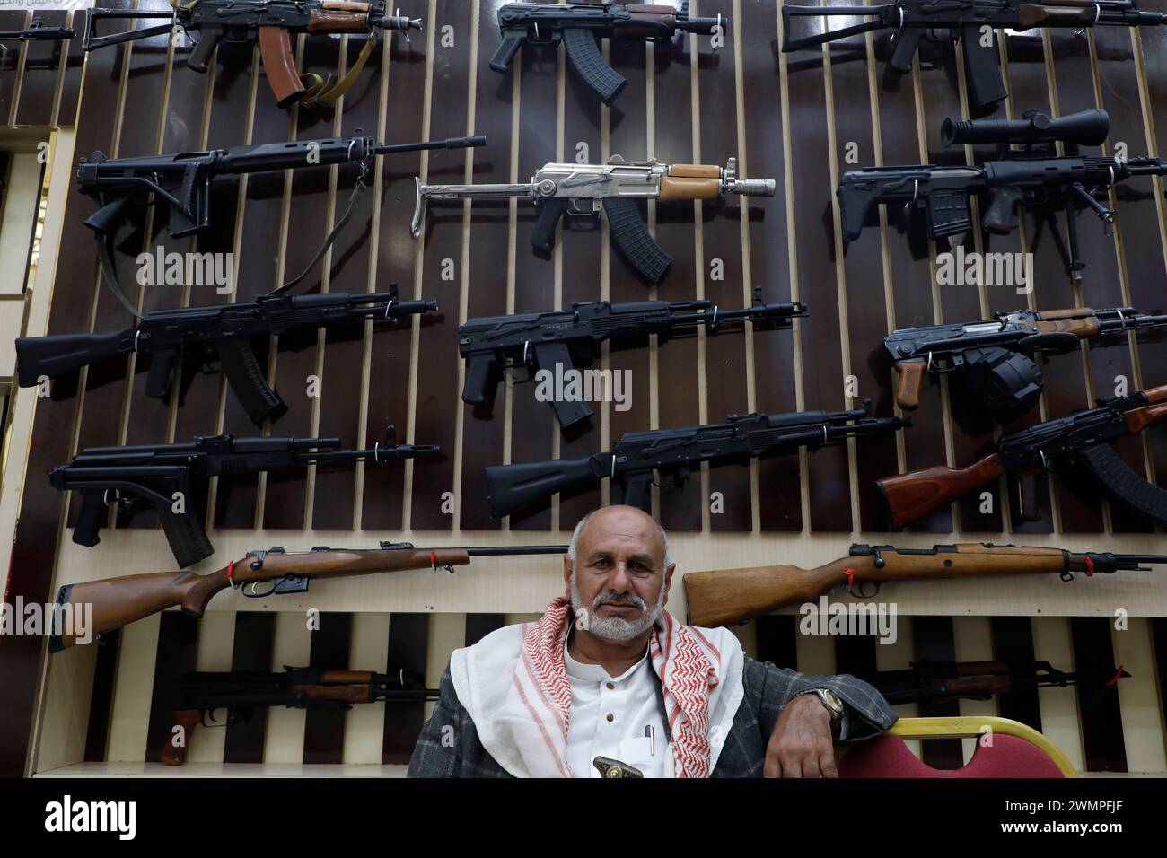 A shopkeeper sits in his gun shop in a shopping mall in Sanaa, Yemen ...